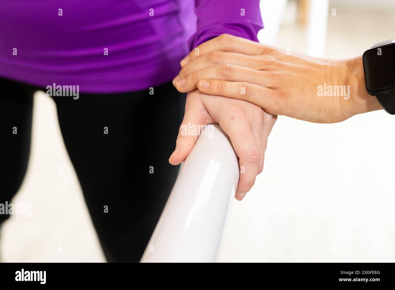 Holding onto parallel bars, person receiving support during physical ...