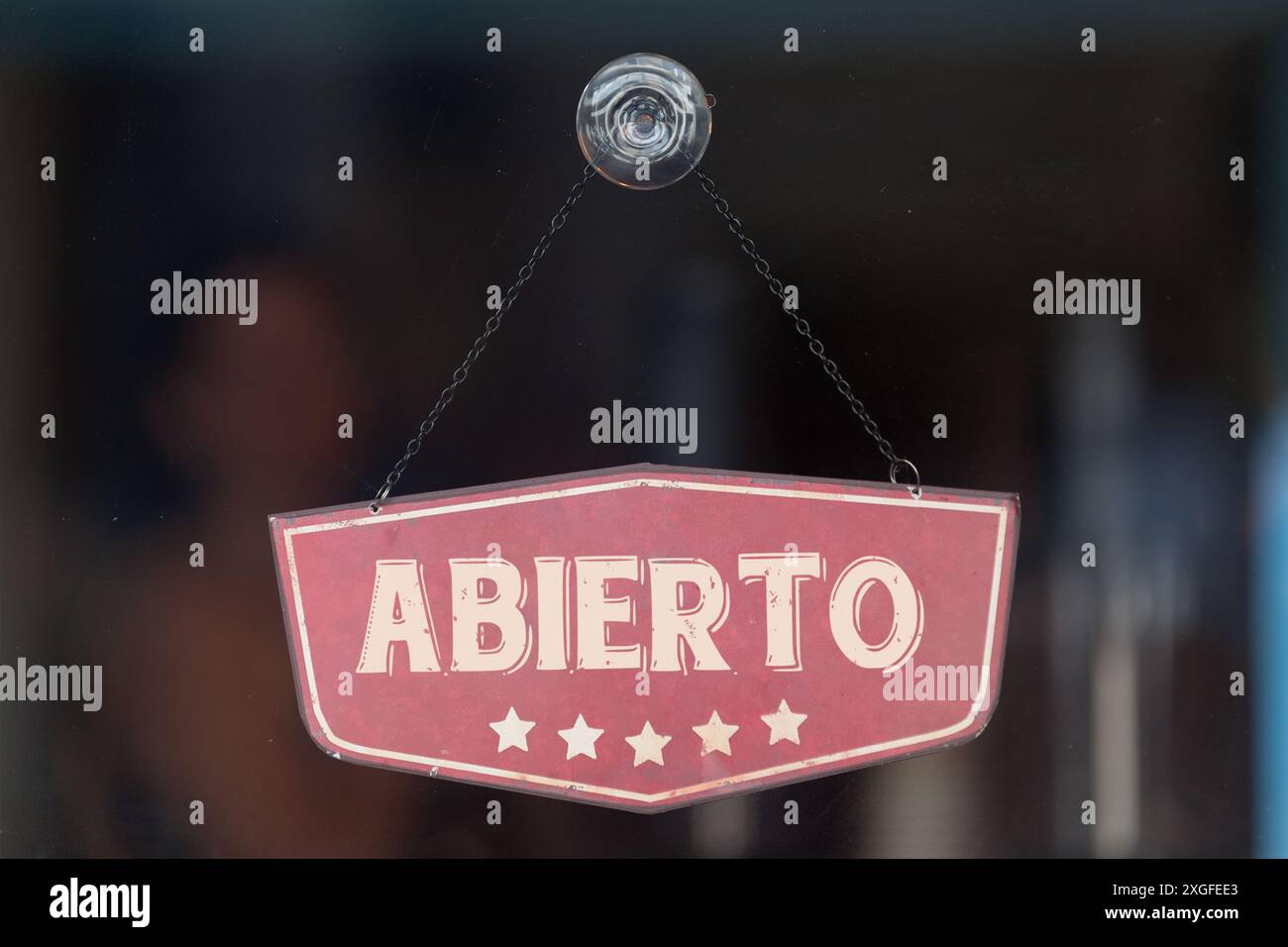 Old fashioned sign in the window of a shop saying in Spanish "Abierto ...