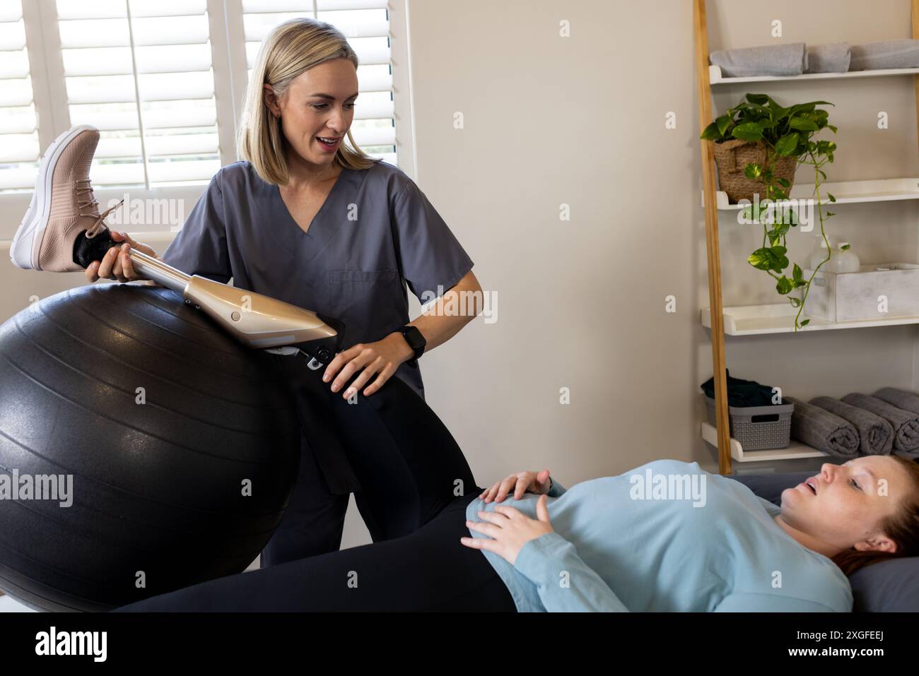Physical therapist assisting woman with prosthetic leg during ...