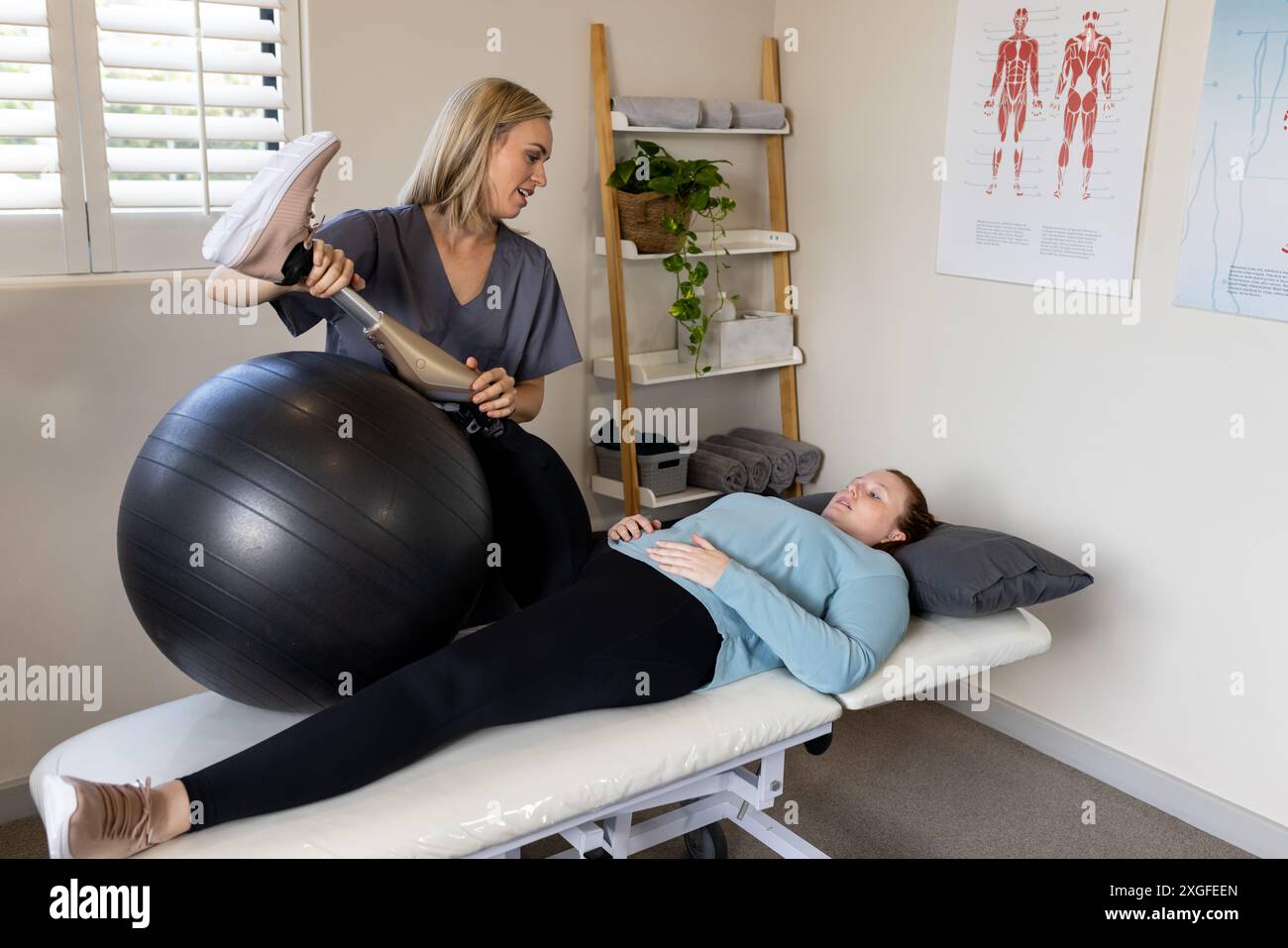 Physical therapist assisting woman with prosthetic leg using exercise ...
