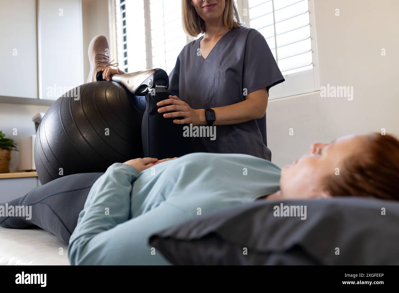 Physical therapist assisting patient with prosthetic leg using exercise ...