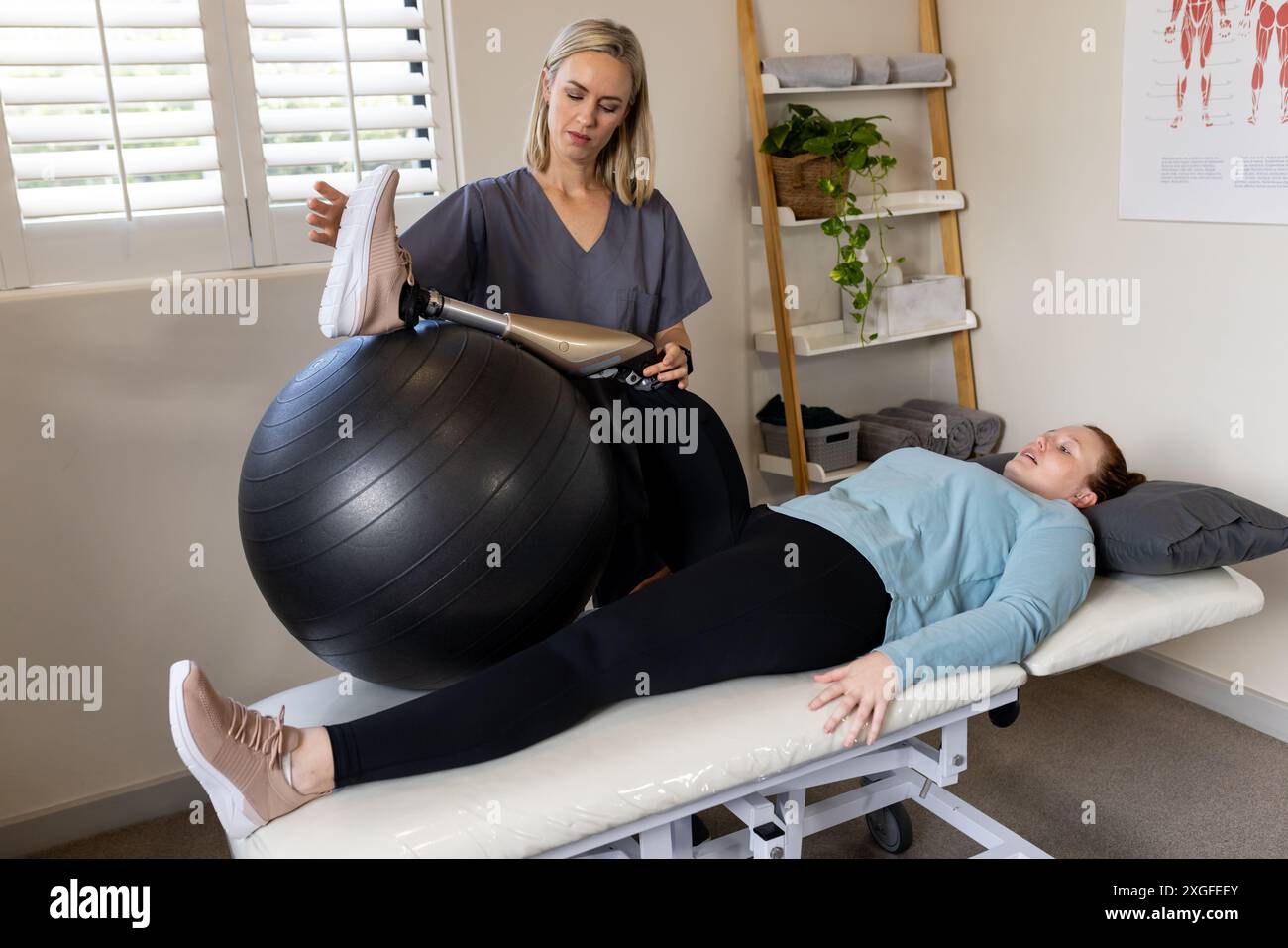 Physical therapist assisting woman with prosthetic leg during exercise session Stock Photo - Alamy