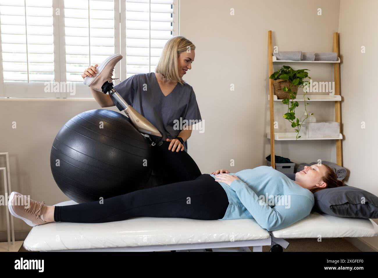 Physical therapist assisting woman with prosthetic leg using exercise ...