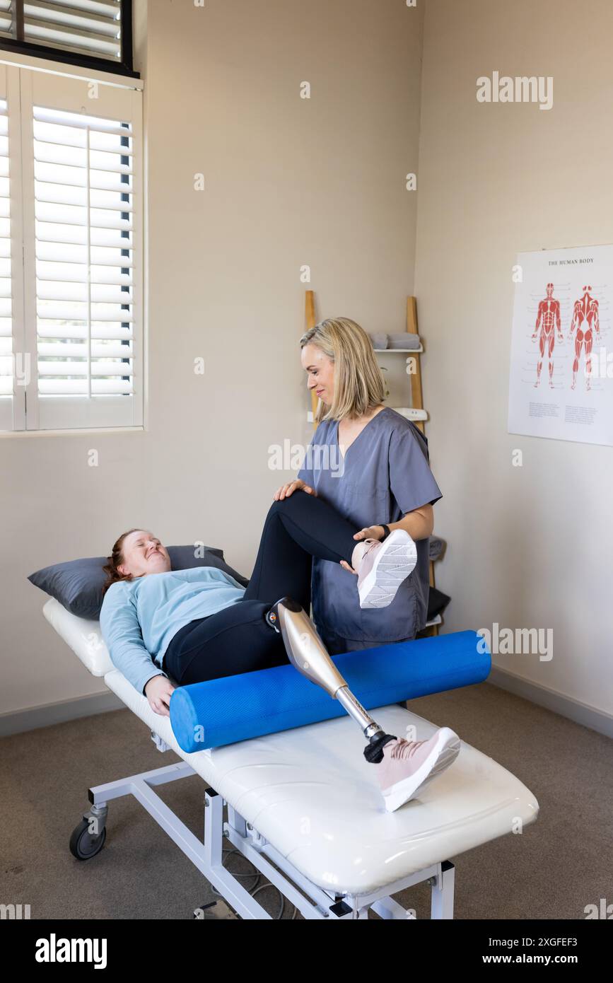 Physical therapist assisting woman with prosthetic leg during ...