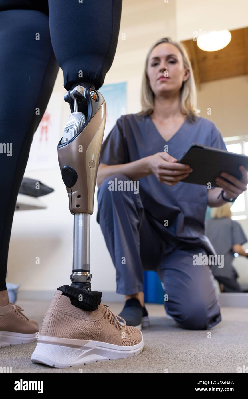 Therapist in prosthetic medical clinic examining patient's prosthetic ...