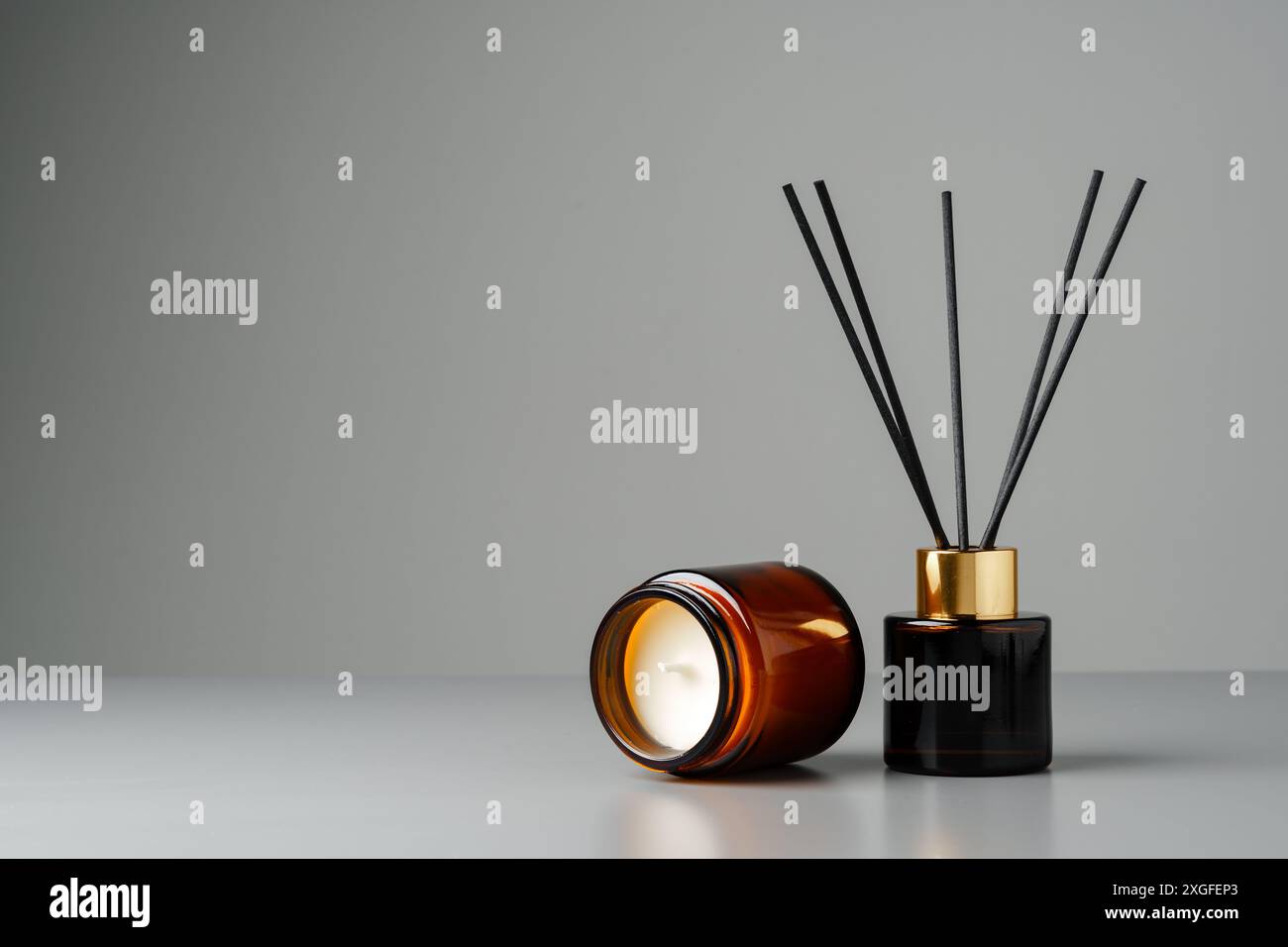 Amber Glass Candle and Reed Diffuser on Grey Surface Stock Photo - Alamy