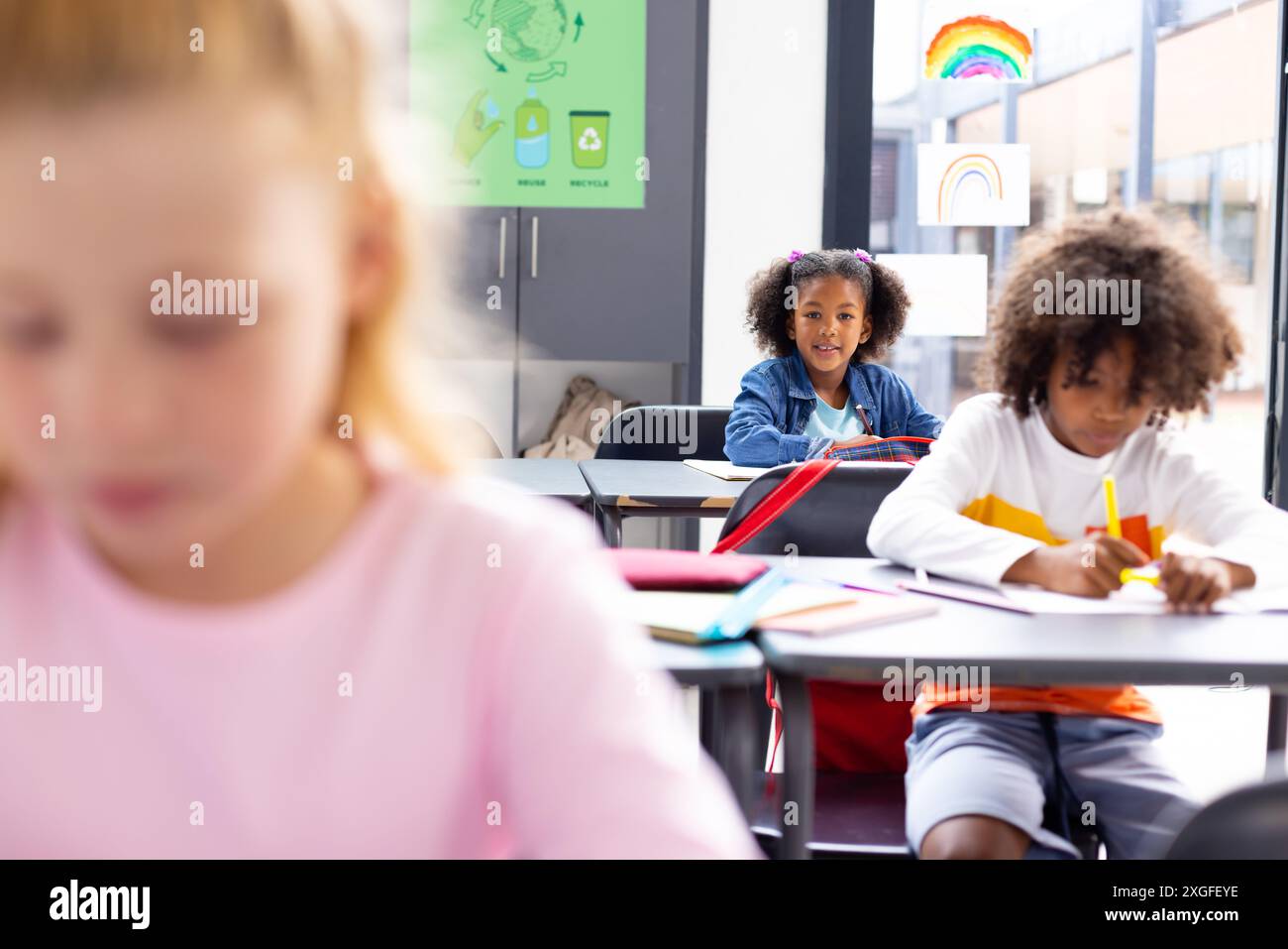 Happy diverse schoolchildren sitting at desks in school classroom Stock ...
