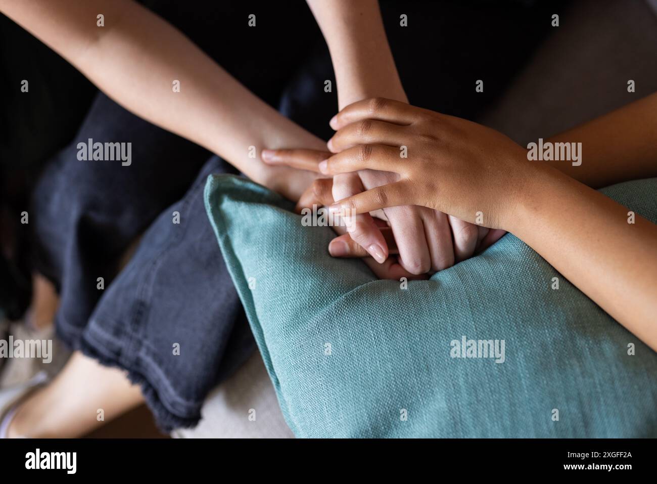 Holding hands, three women friends showing support and comfort on couch ...