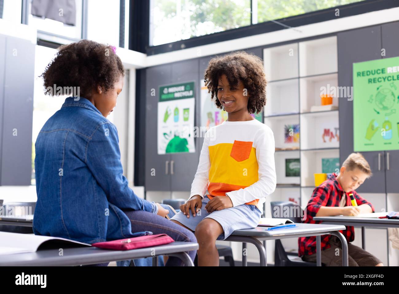 Happy diverse schoolchildren sitting at desks in school classroom Stock ...