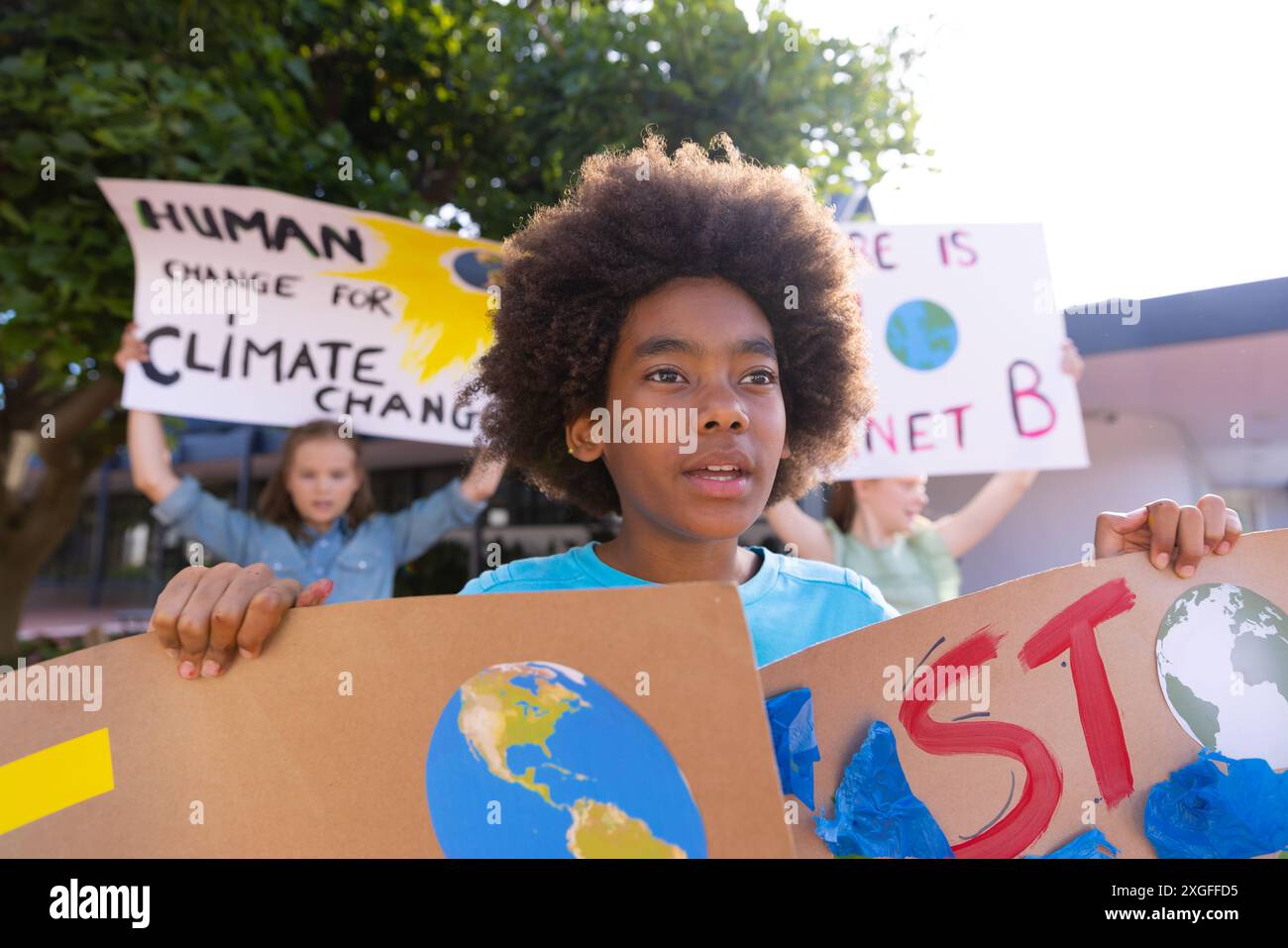 Happy diverse schoolchildren holding ecology posters made in art class ...