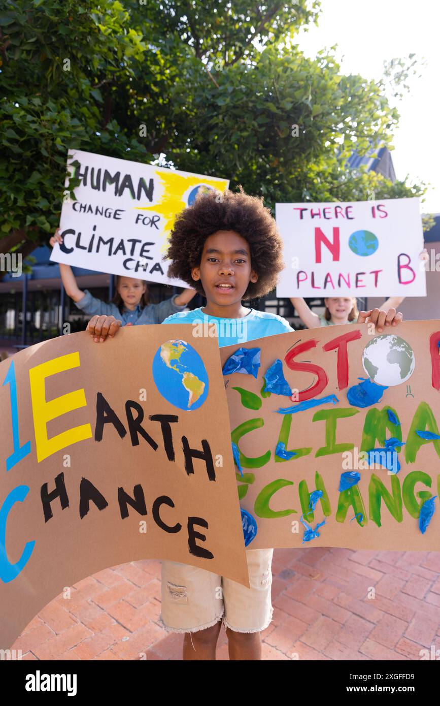 Happy diverse schoolchildren holding ecology posters made in art class ...