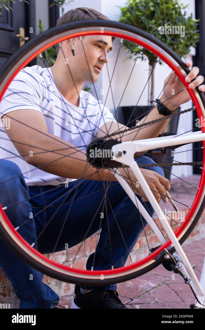 Repairing bicycle wheel, man adjusting spokes and checking alignment ...