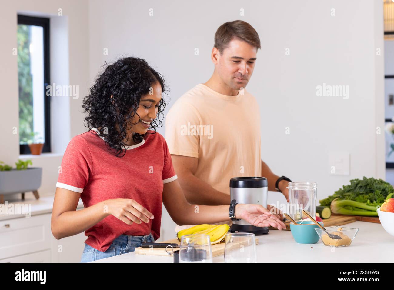 Preparing healthy smoothie, young couple using blender in modern ...