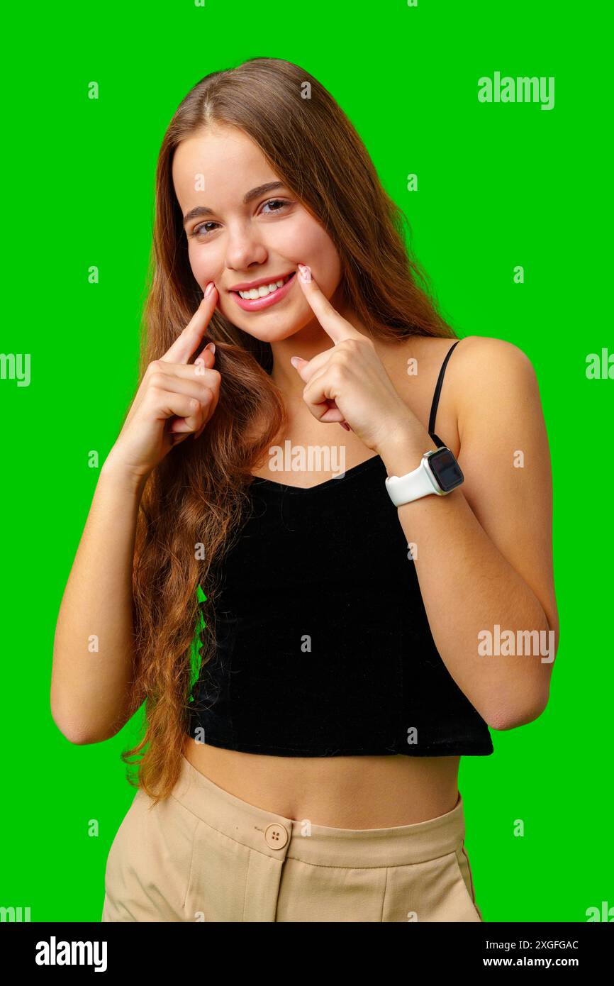 Young Woman Making Hand Sign With Fingers against green background ...