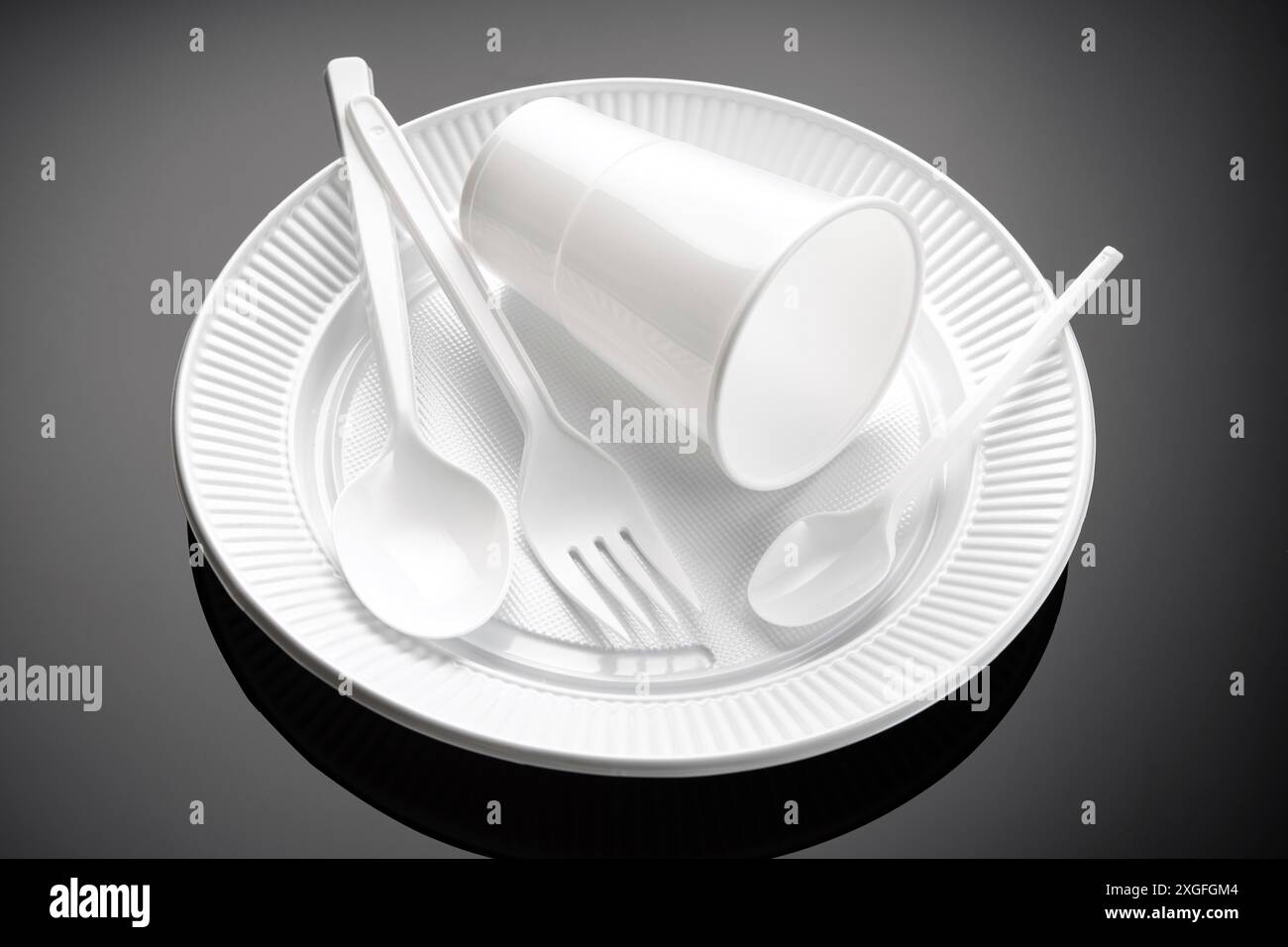 Plastic dishware. White cup, plate, fork and spoon Disposable plastic ...