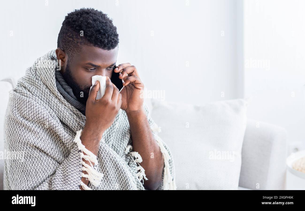 Sick Man Talking on Phone While Blowing Nose Stock Photo - Alamy