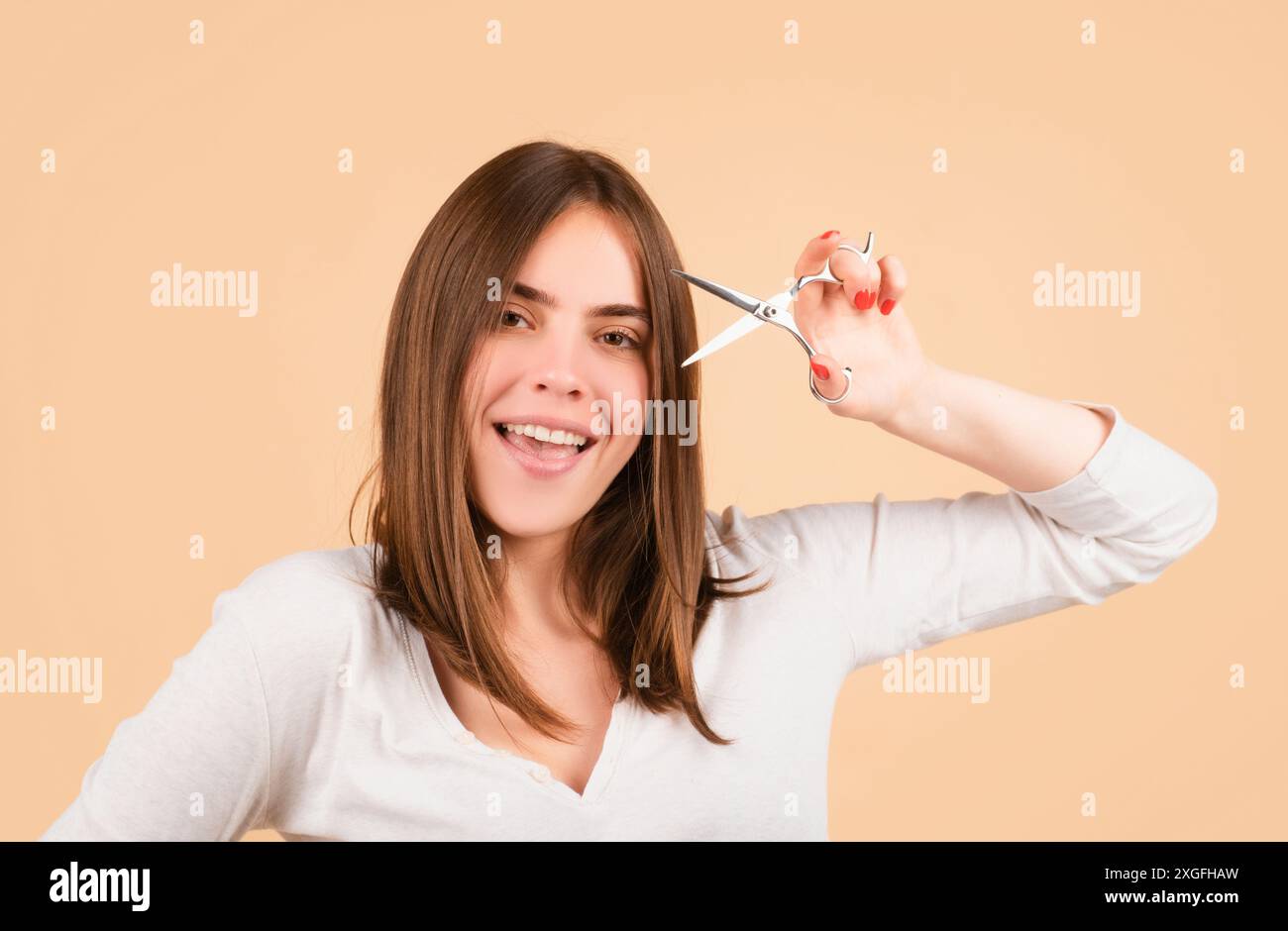 Woman with scissors having hair cut. Beautiful girl with straight hair ...