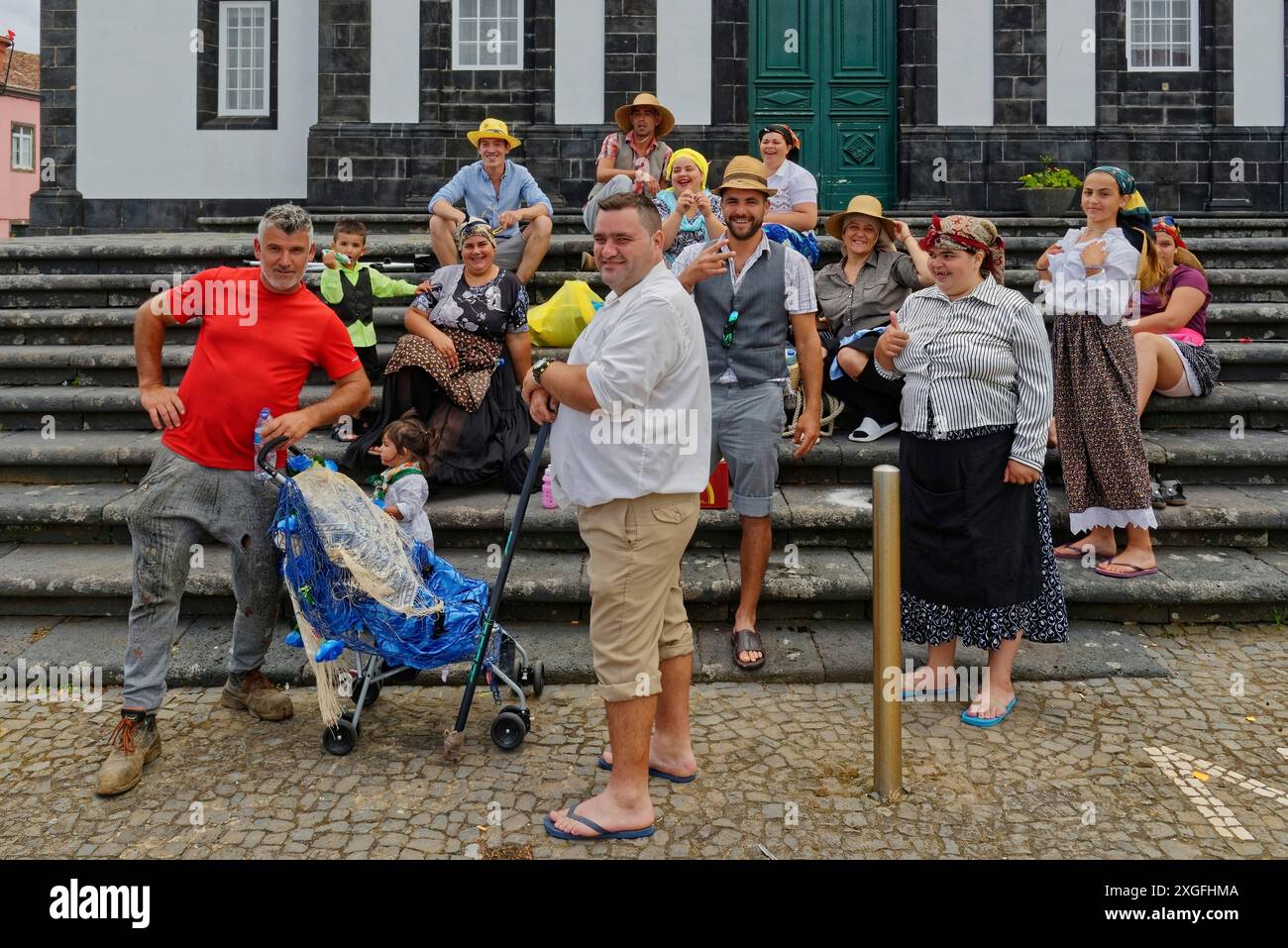 Group of cheerful people in traditional dress posing on a staircase ...