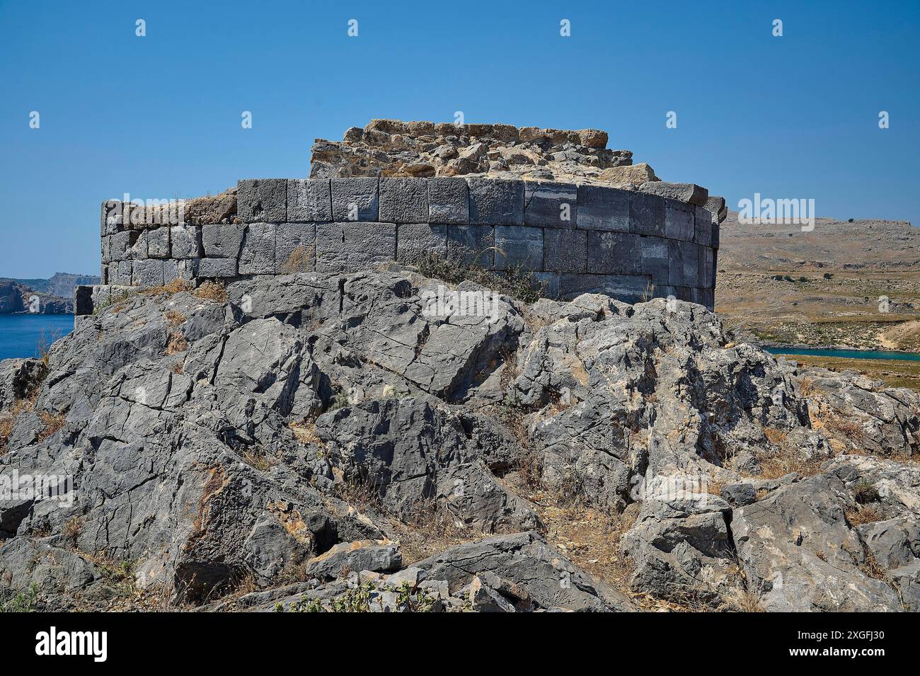 Crumbling ancient ruins in a rocky landscape under a blue sky, tomb of ...