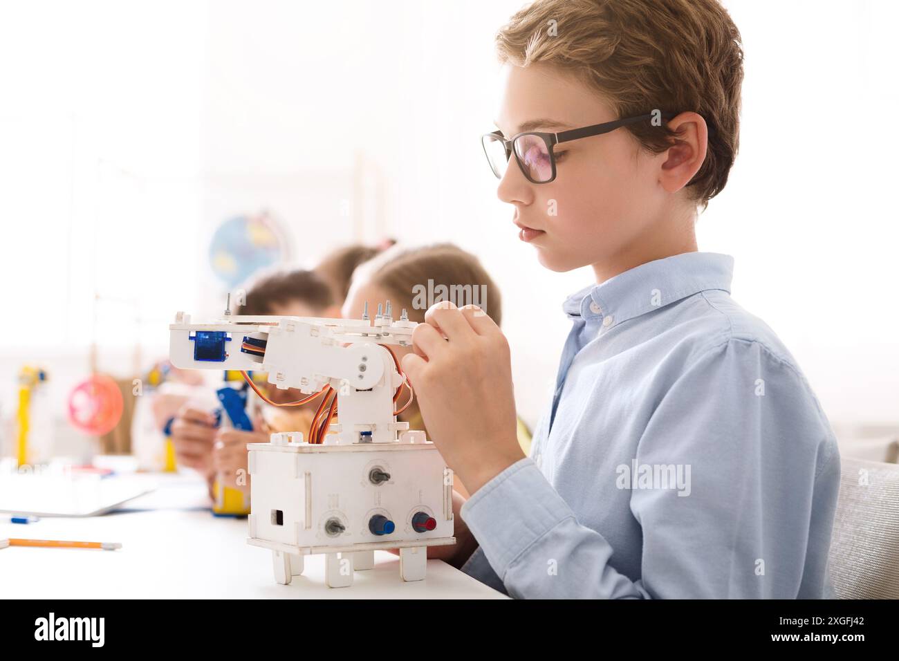 Young Boy Building Robotic Arm In Classroom Setting Stock Photo - Alamy