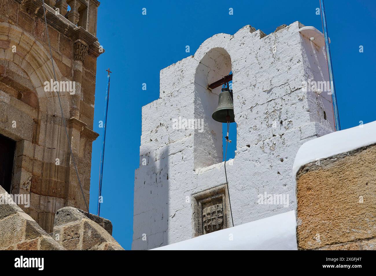 A striking bell tower made of white stones under a bright blue sky in ...