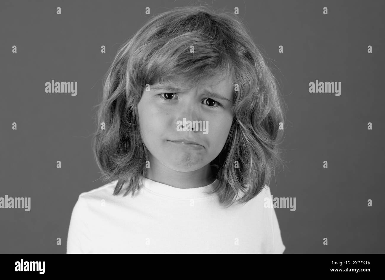 Funny angry child on studio isolated background. Upset kid boy with mad ...