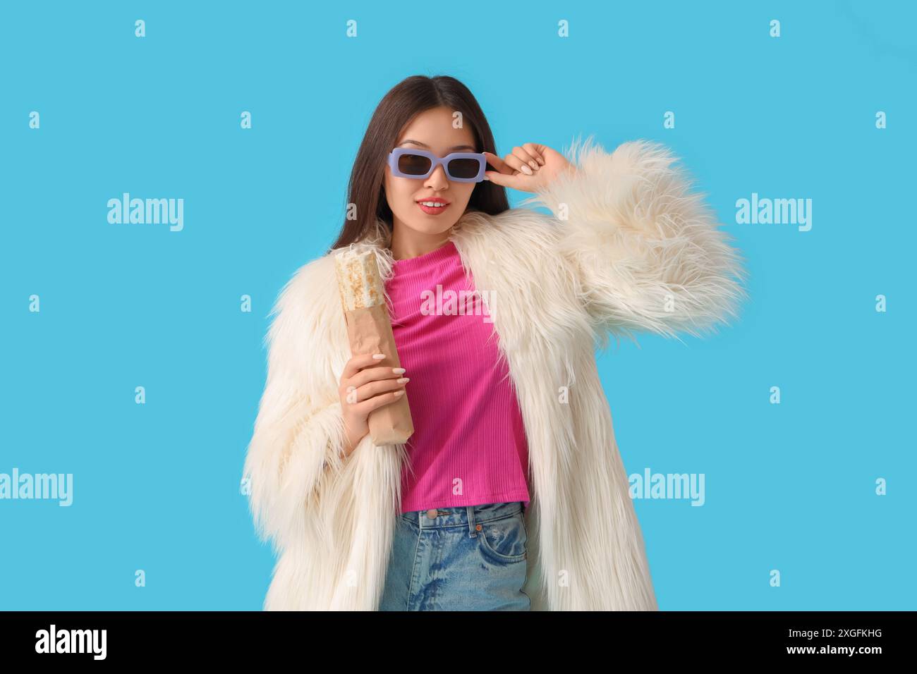 Stylish young Asian woman with doner kebab on blue background Stock ...