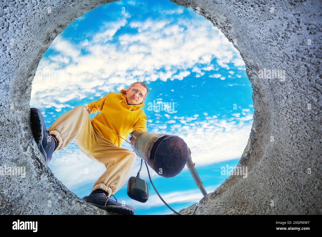 Homeowner submerging submersible sewage pump in wastewater of septic ...