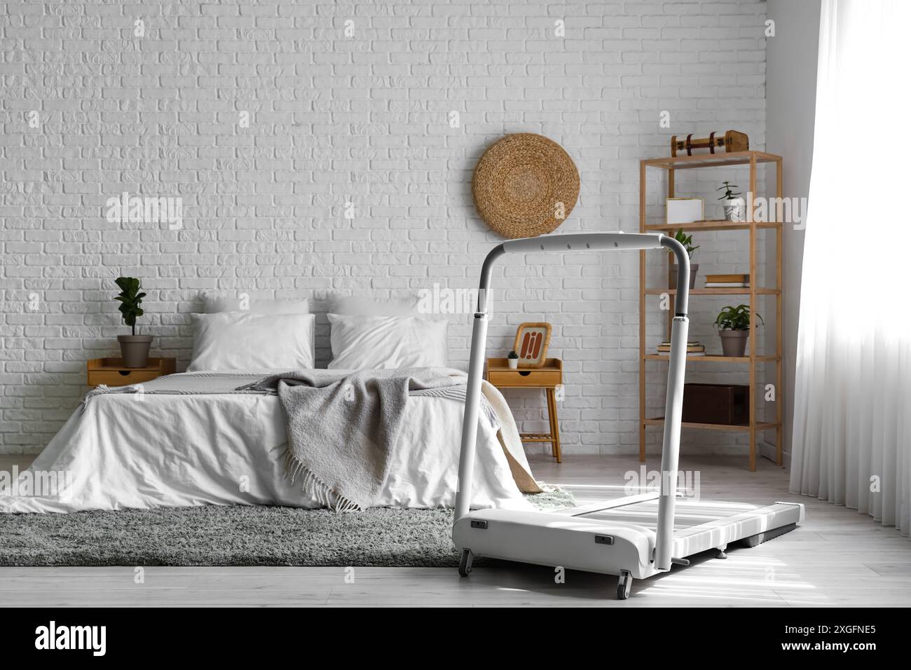Interior of light bedroom with treadmill and shelf unit Stock Photo - Alamy