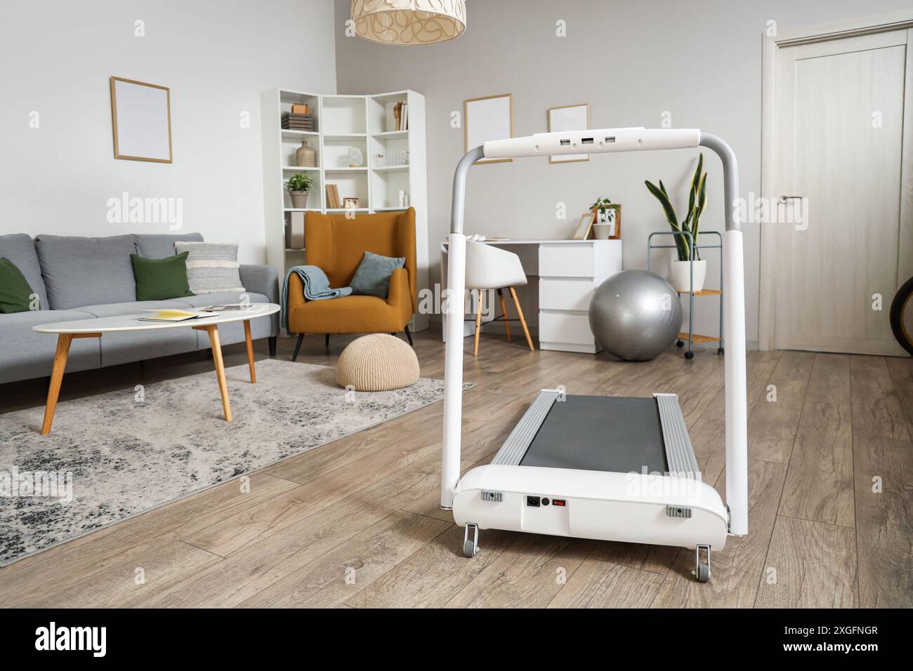 Modern treadmill in interior of living room Stock Photo - Alamy