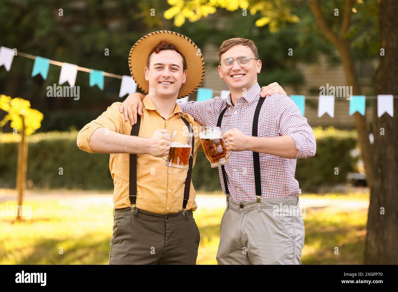 Young men in traditional German clothes with beer celebrating ...
