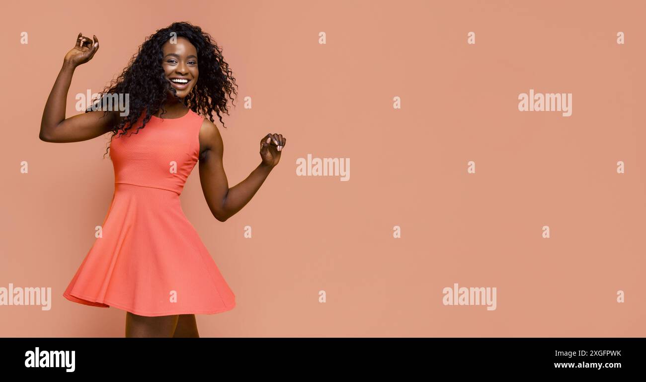 Happy Woman Wearing Pink Dress Dancing Against Peach Background Stock ...