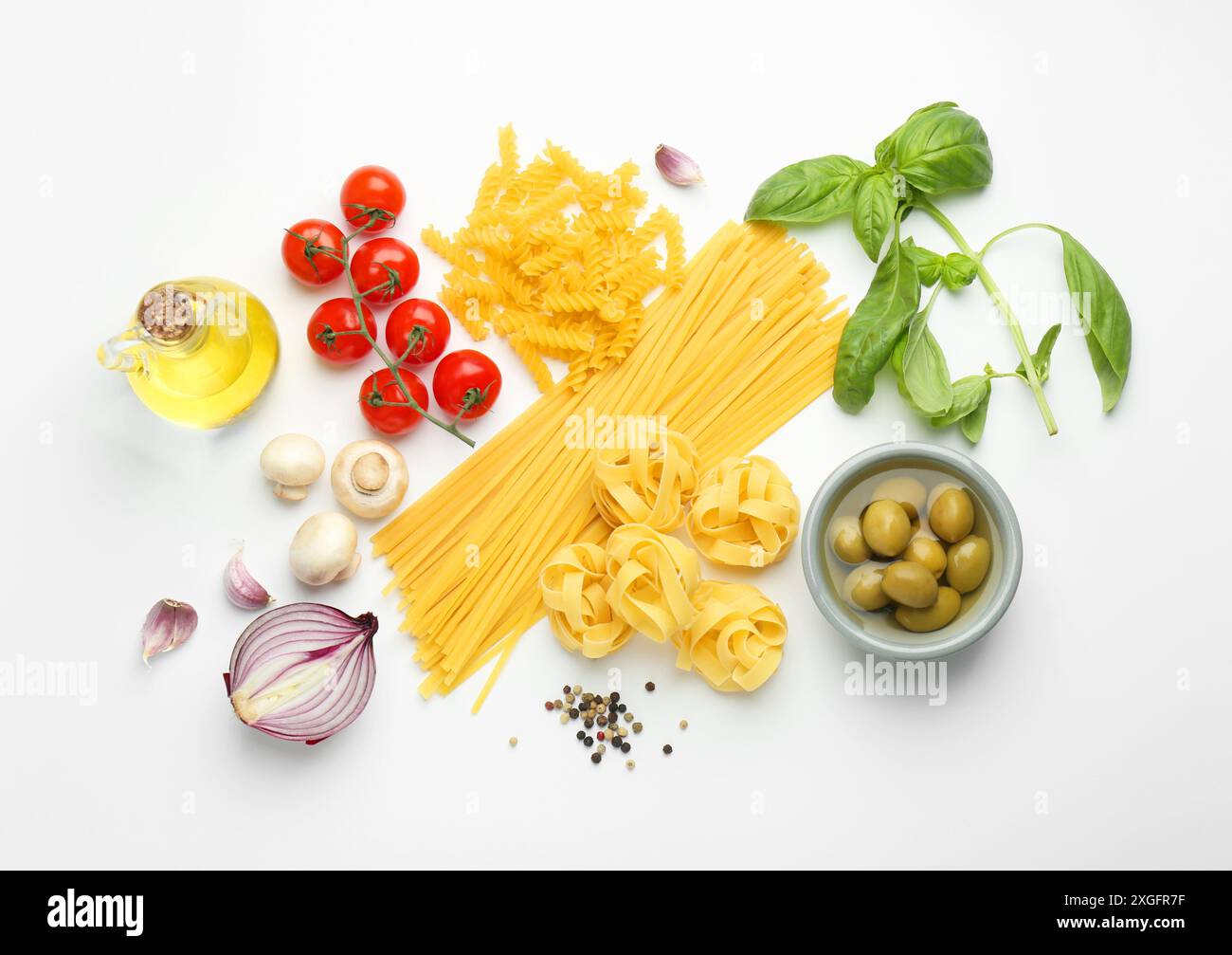 Different types of pasta, spices and products on white background, top ...