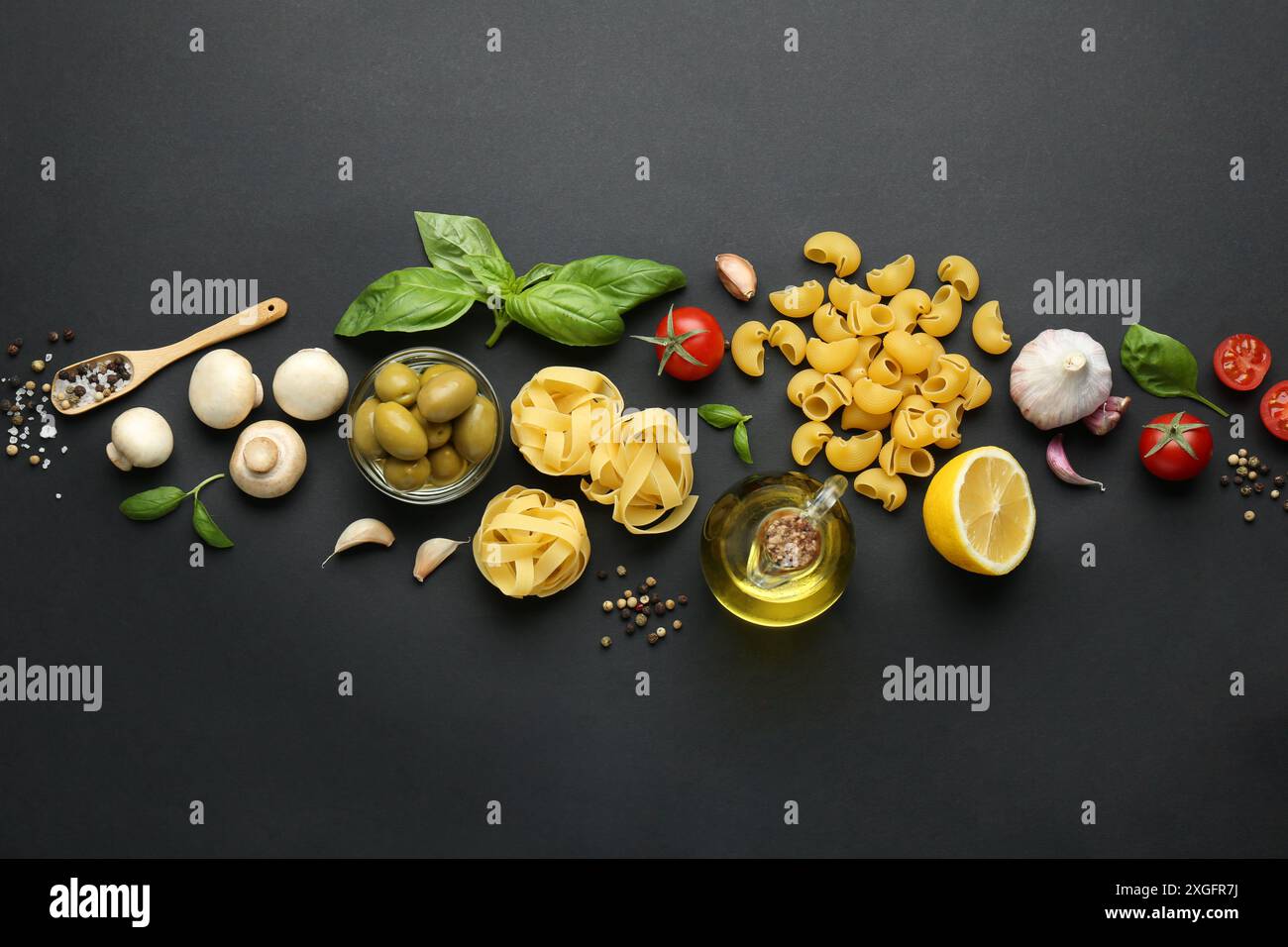 Different types of pasta, spices and products on black background, flat ...