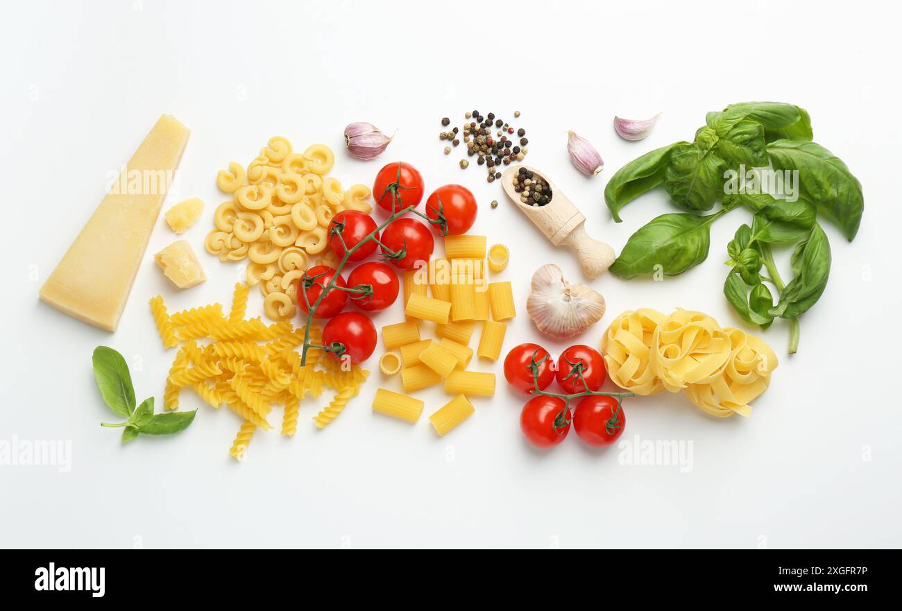 Different types of pasta, spices and products on white background, top ...