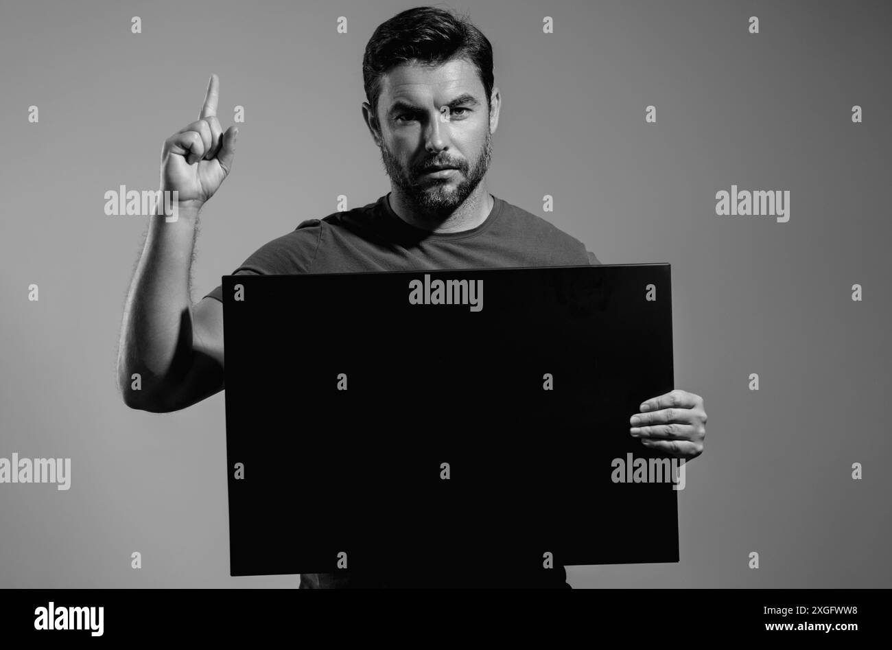 Happy man hold board thinking of idea on studio background. Portrait of ...