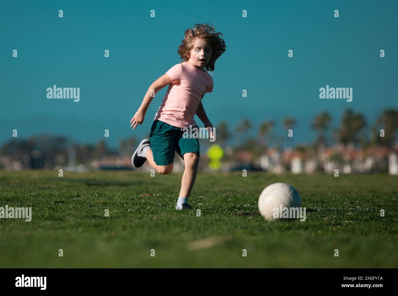 Soccer kids, child boy play football outdoor. Young boy with soccer ball doing kick. Football ...