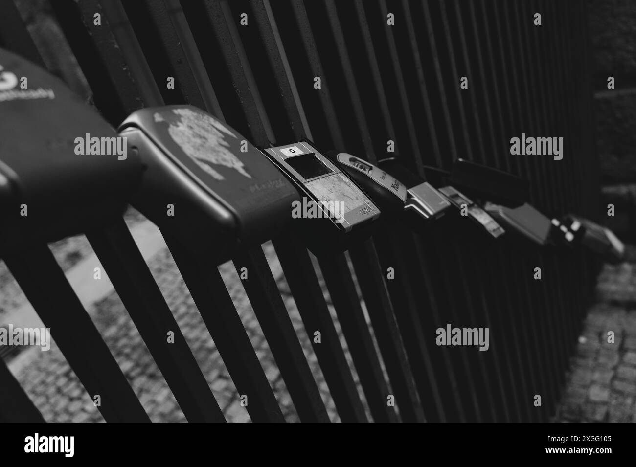 A row of worn lock boxes attached to an iron fence in Porto, used for ...