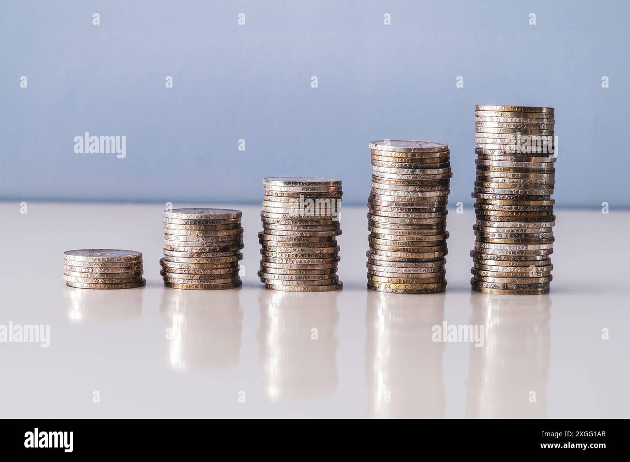 Five stacks of old silver coins forming an ascending graph on a ...