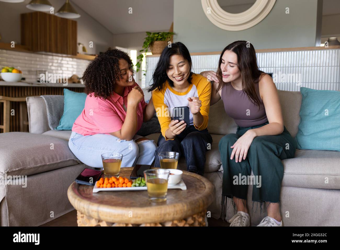 Three friends sitting on couch hi-res stock photography and images - Alamy