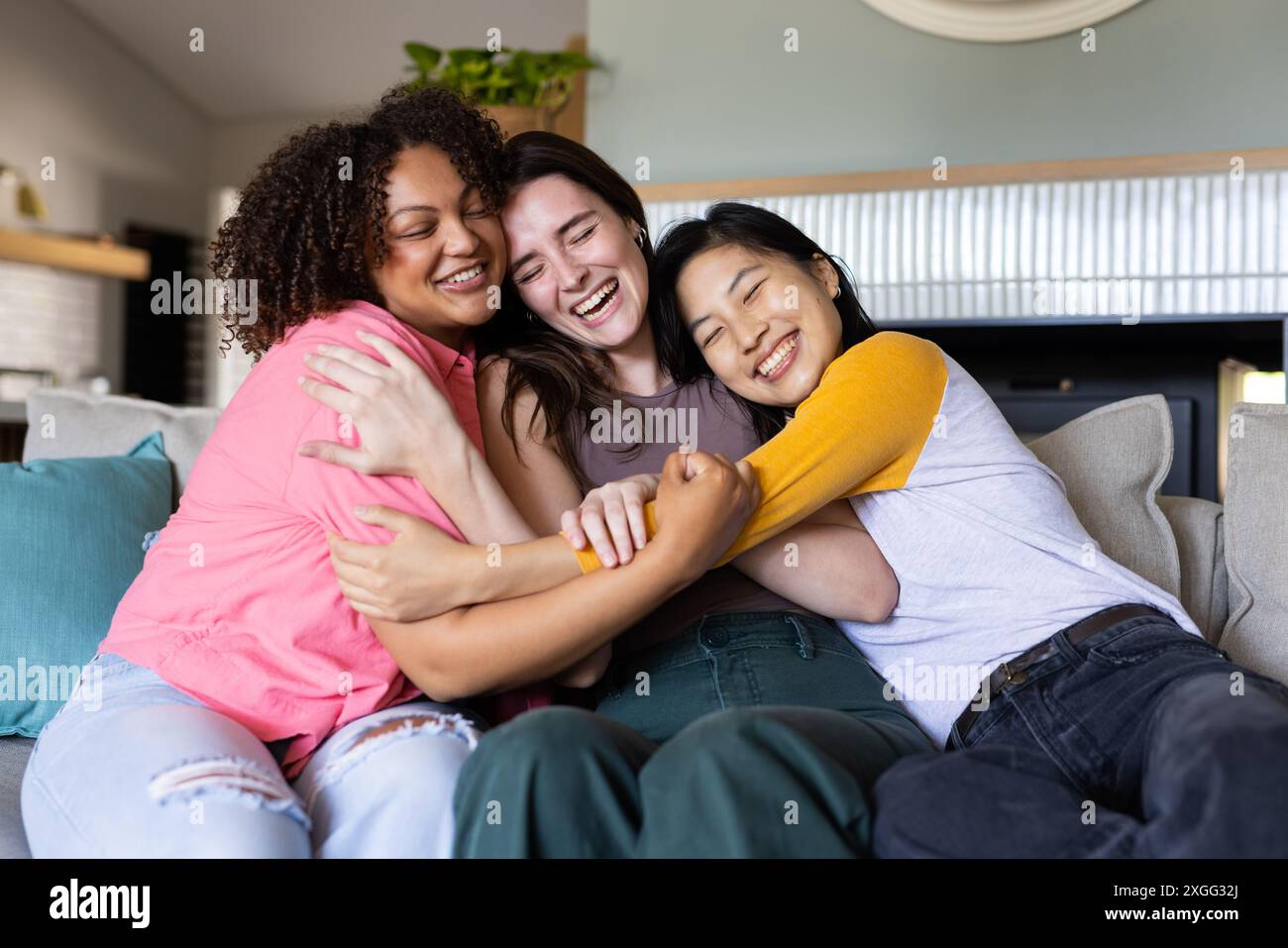 Three friends hugging indoors hi-res stock photography and images - Alamy