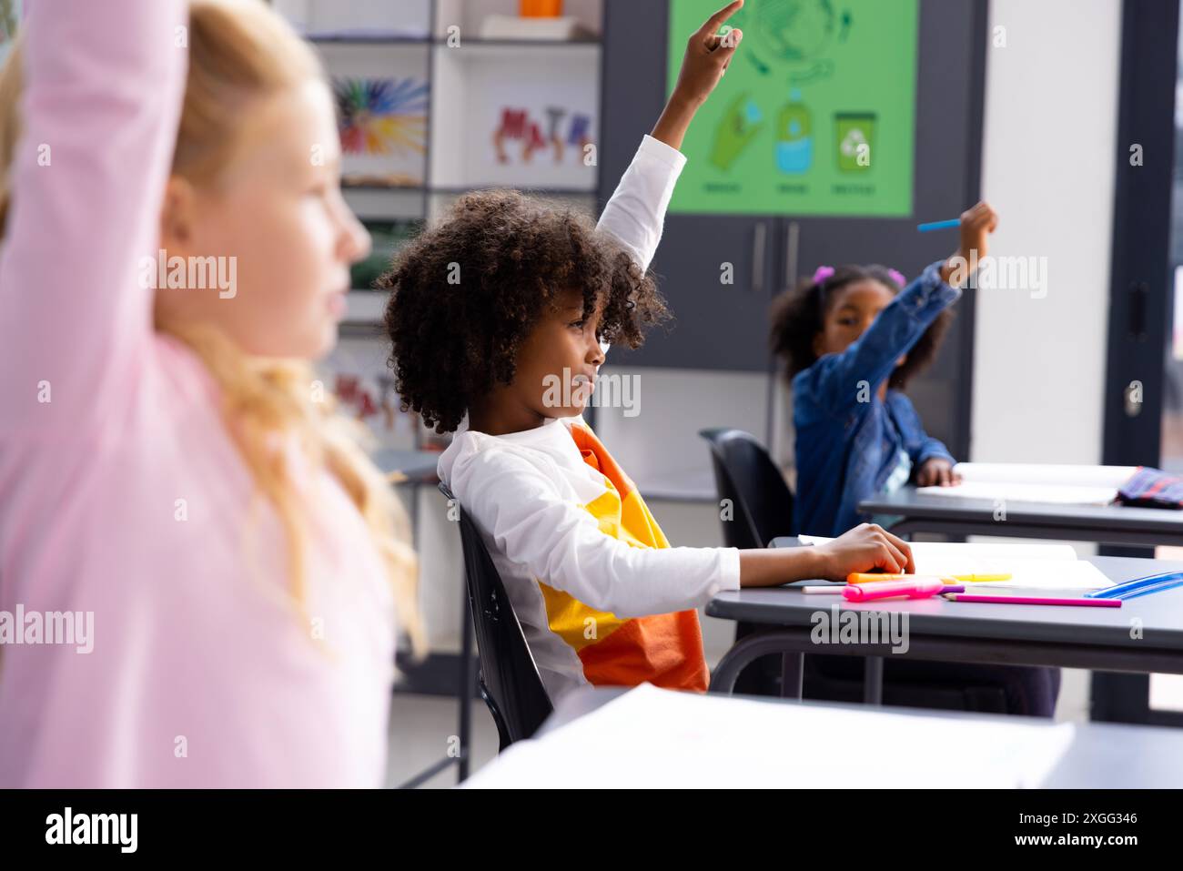 Happy diverse schoolchildren sitting at desks in school classroom Stock ...