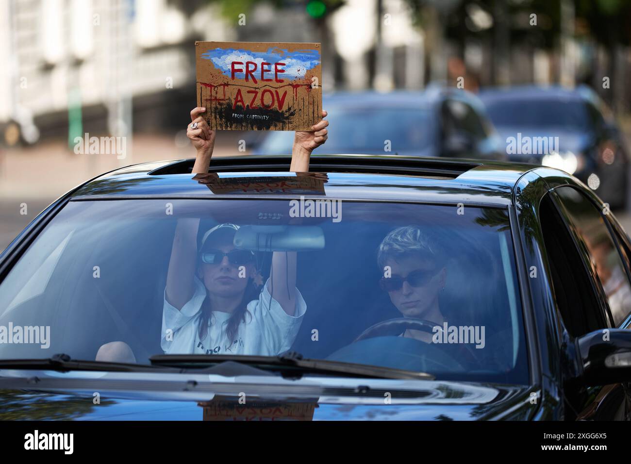 Ukrainian activist shows a sign "Free Azov" out of a car window. Kyiv ...