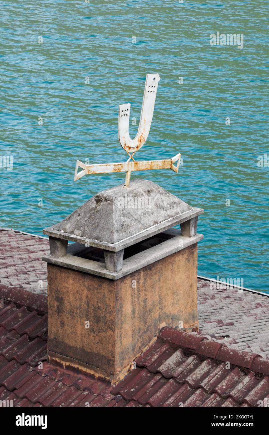 chimney with weathercock in front of the lake, Italy Stock Photo - Alamy