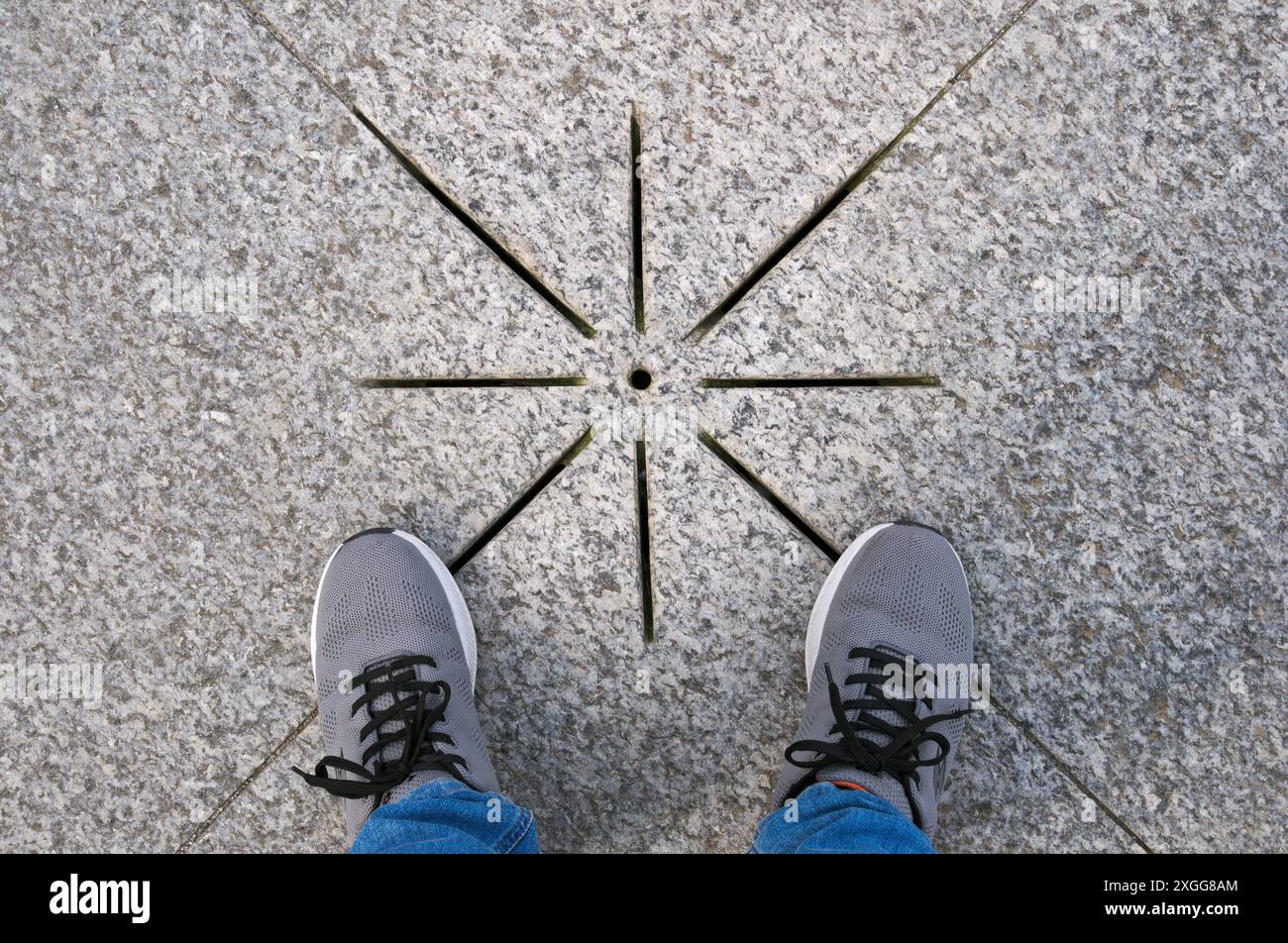 feet in sneakers on stone pavement with star symbol Stock Photo - Alamy