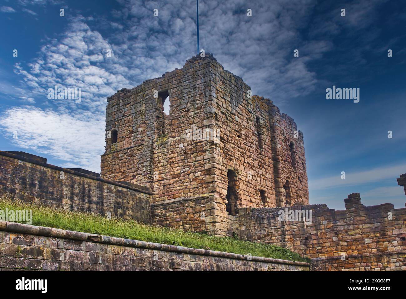 An ancient stone castle ruin with a partially collapsed tower, set ...