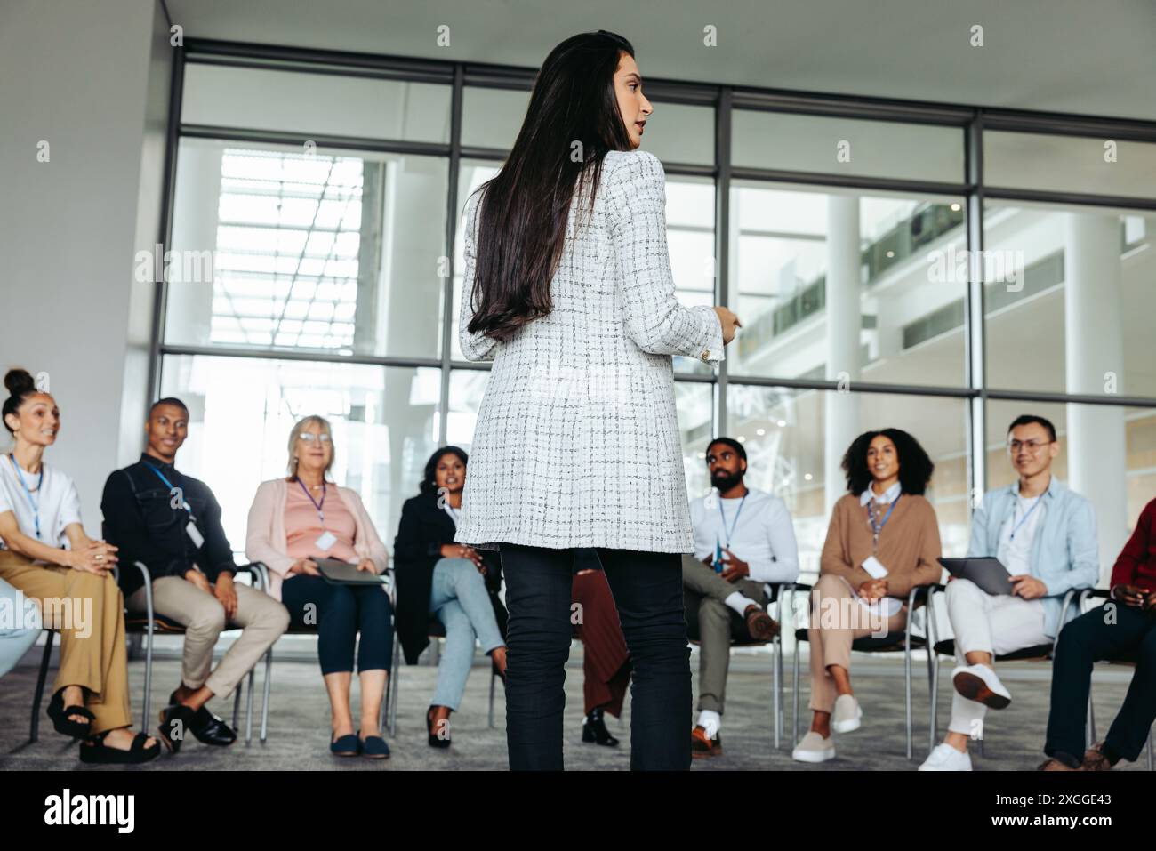 A female speaker is giving a presentation at a conference, engaging a ...