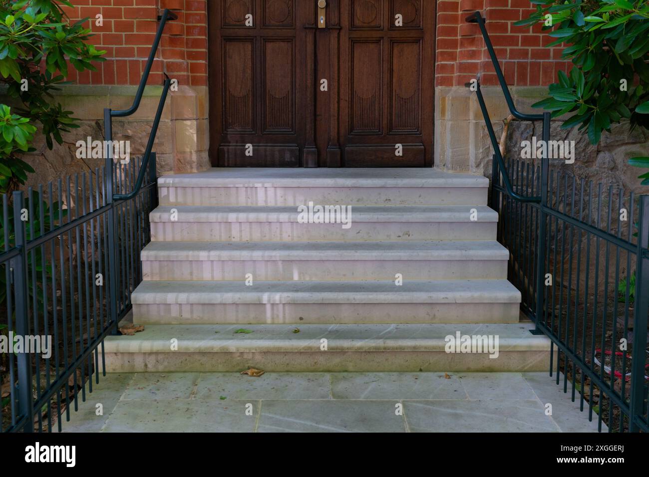 A set of stone steps with railings leading up to a pair of wooden ...