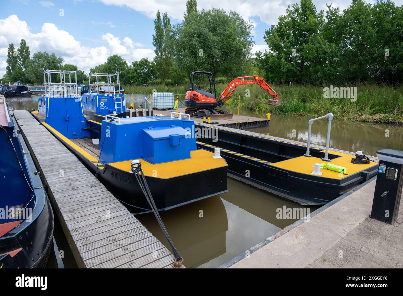 Tow blue and yellow Canal and River Trust workboats moored next to a ...