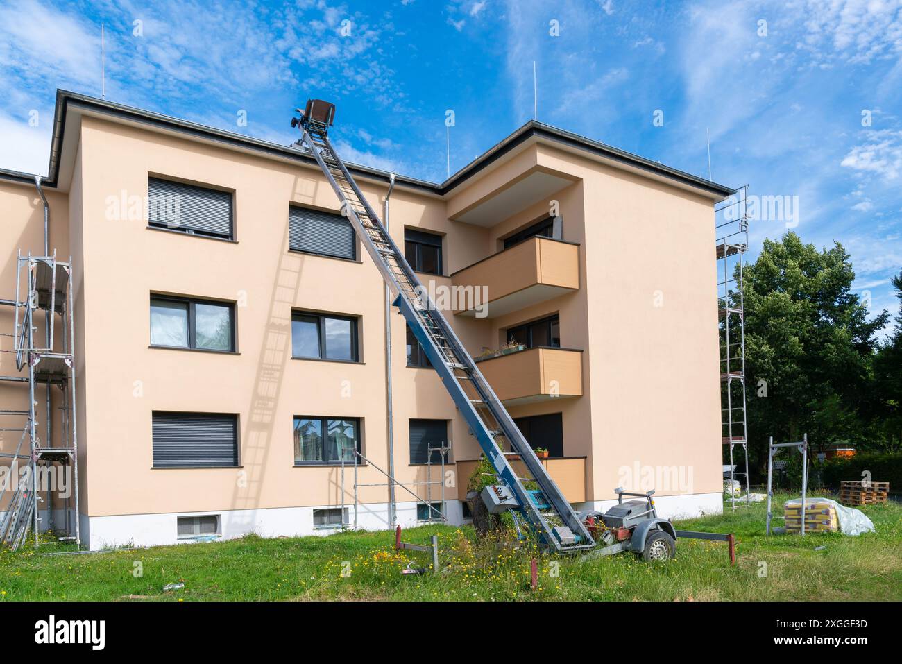 A building is under renovation with a moving platform extending from ...